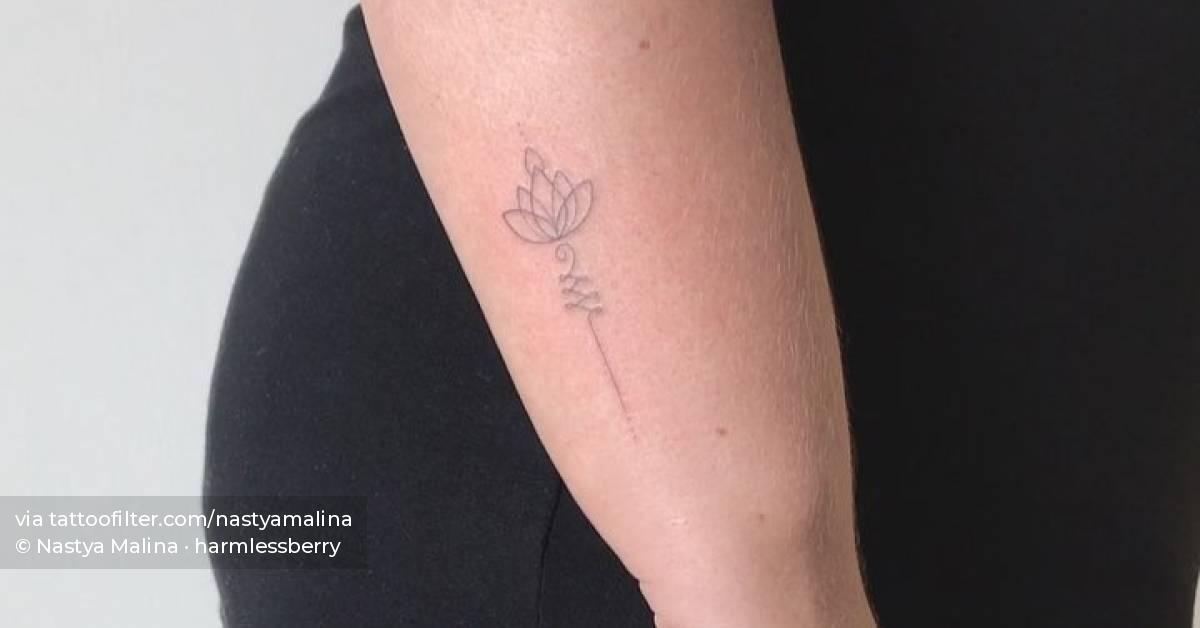 Fine line lotus unalome tattoo on the forearm.