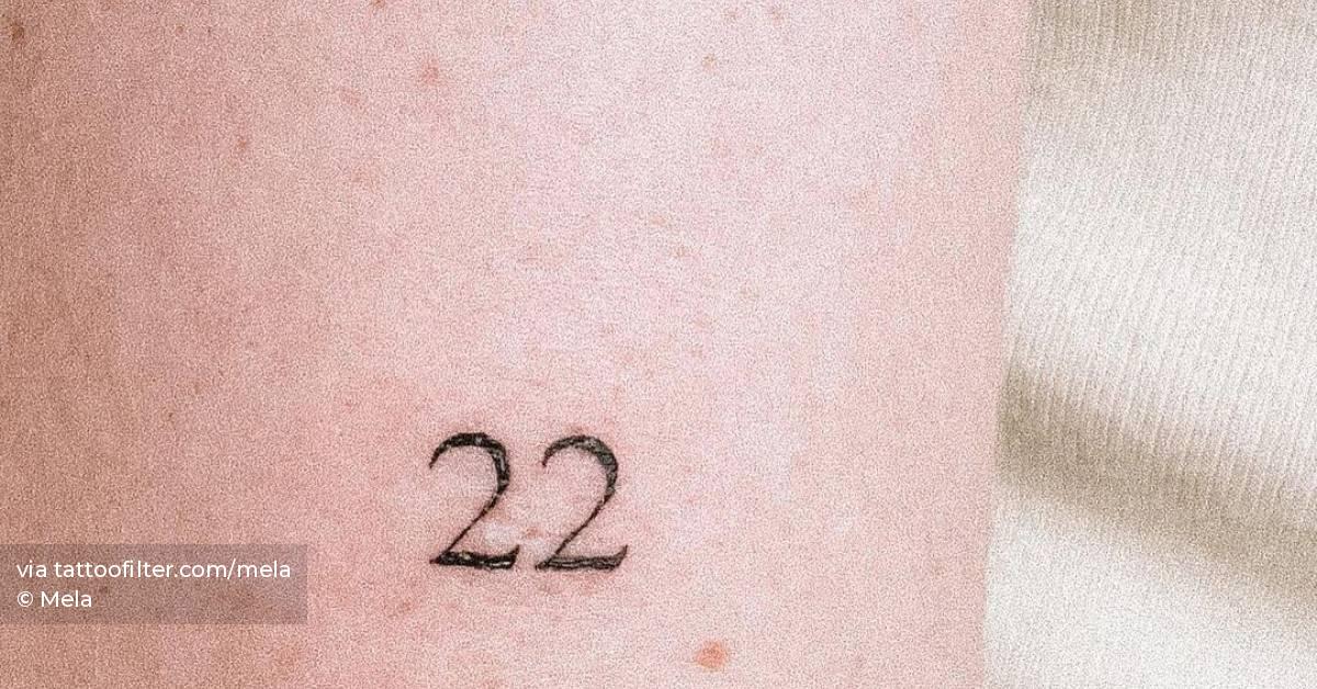 "22" lettering tattoo on the tricep.