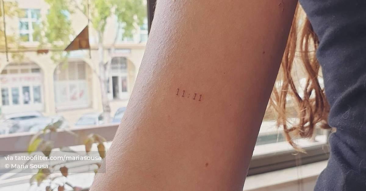 "11:11" lettering tattoo on the bicep.