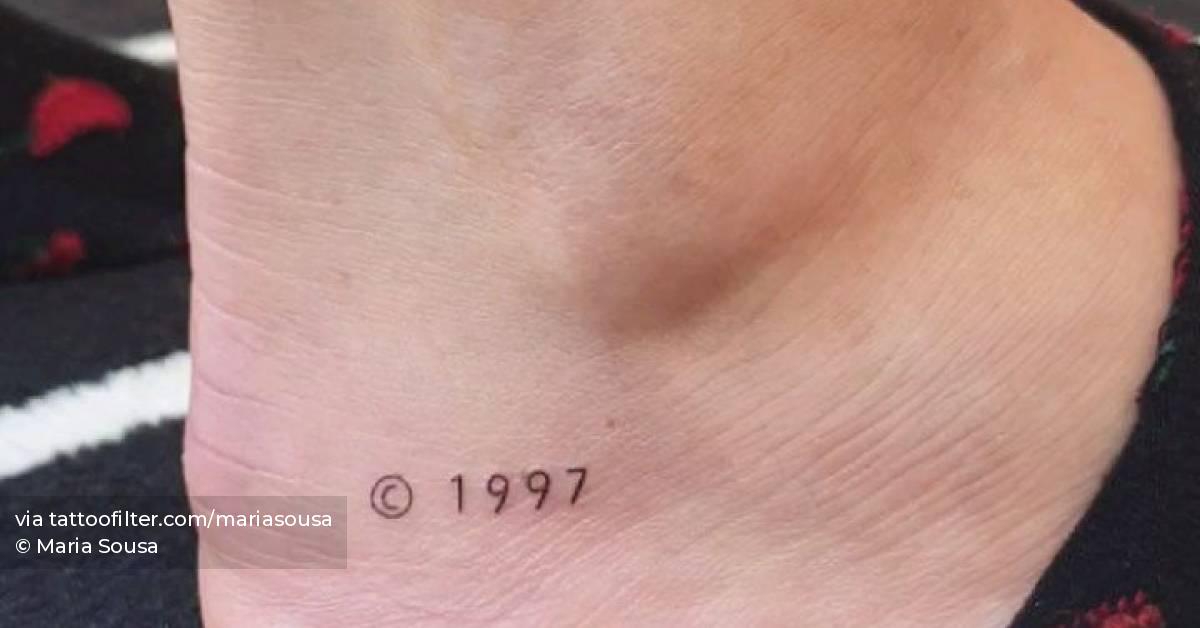 "1997" lettering tattoo on the ankle.