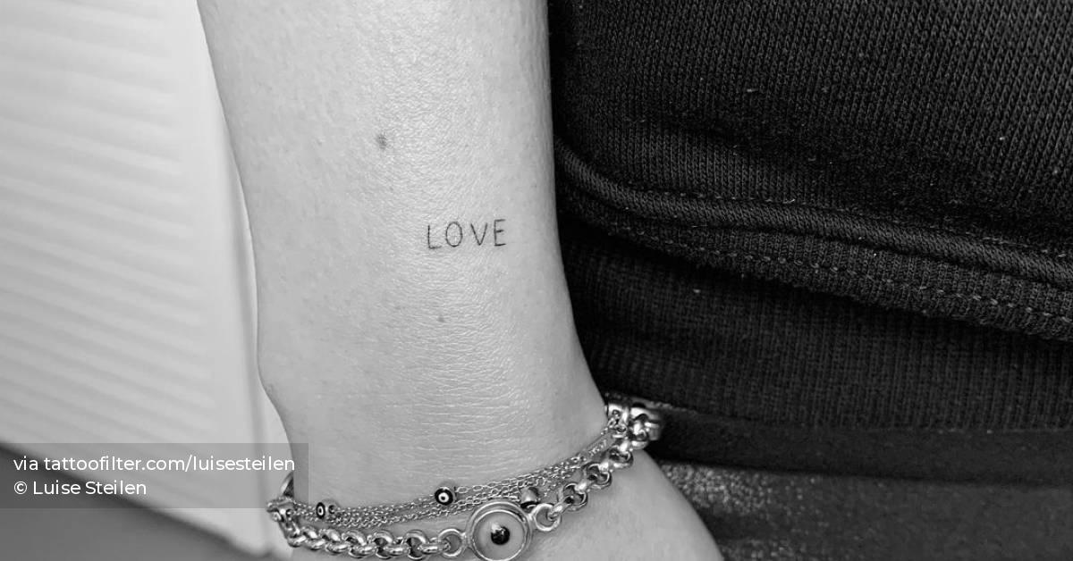 "Love" lettering tattoo on the wrist.