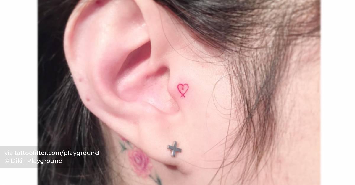 Micro red heart tattoo located on the ear.