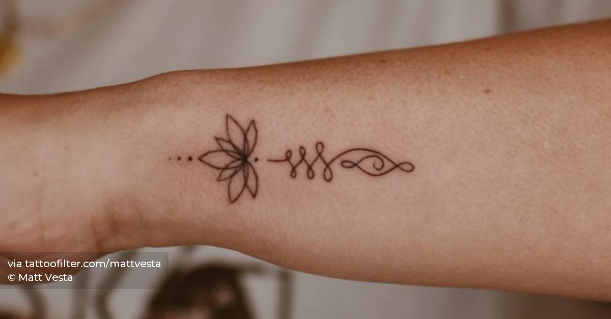 Fine line lotus unalome tattoo located on the wrist.