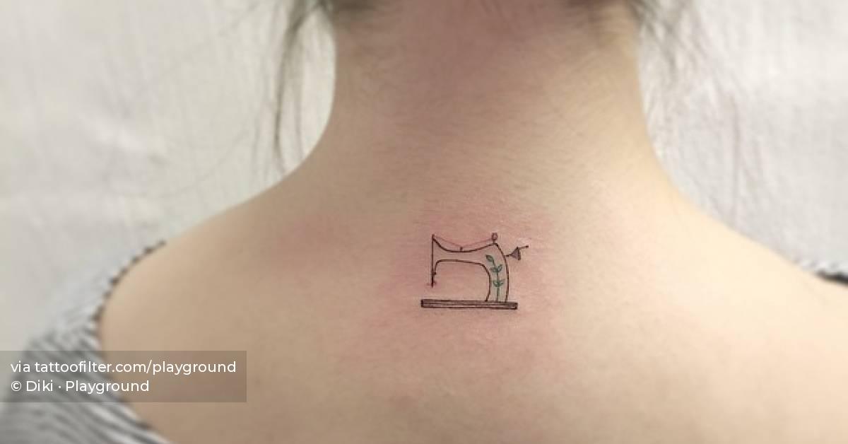 Fine line sewing machine tattoo done on the upper back.