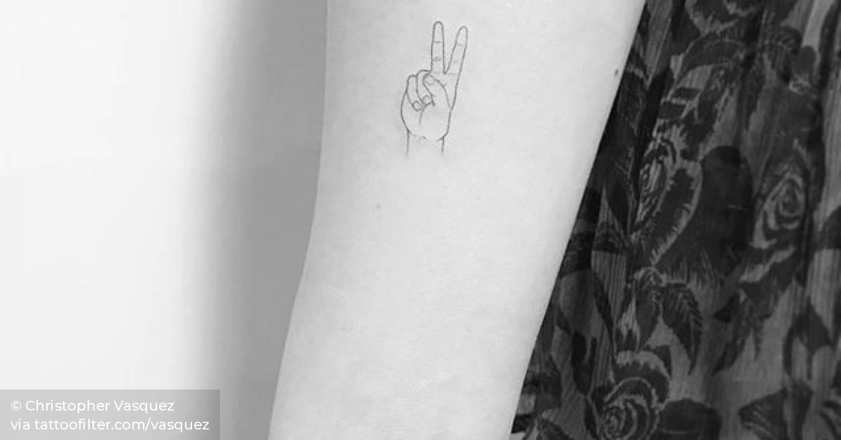 V sign tattoo on the right forearm.