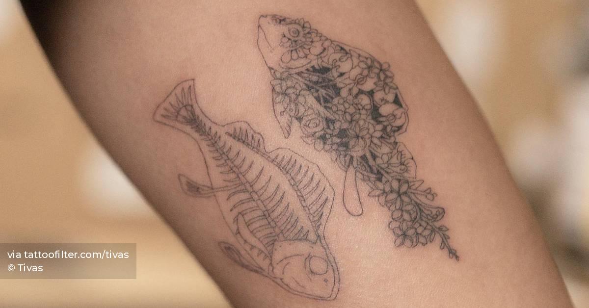 Floral and skeleton fish tattoo located on the inner