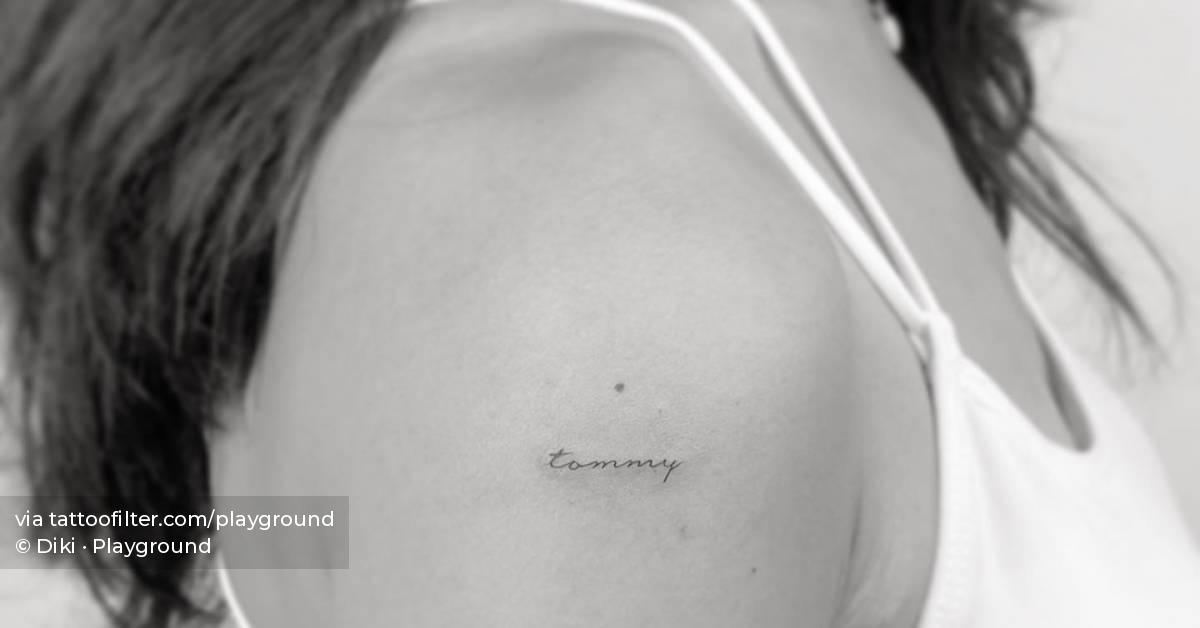 Tattoo of the name "Tommy" handwritten on the upper