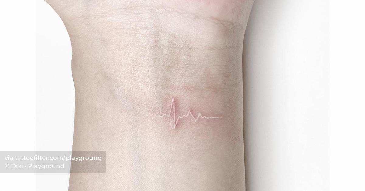 Heartbeat tattoo done in white ink, located on the