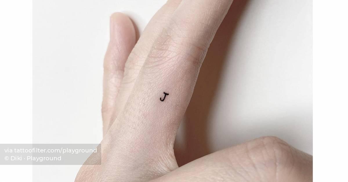 Minimalistic tattoo of the letter "J" located on the