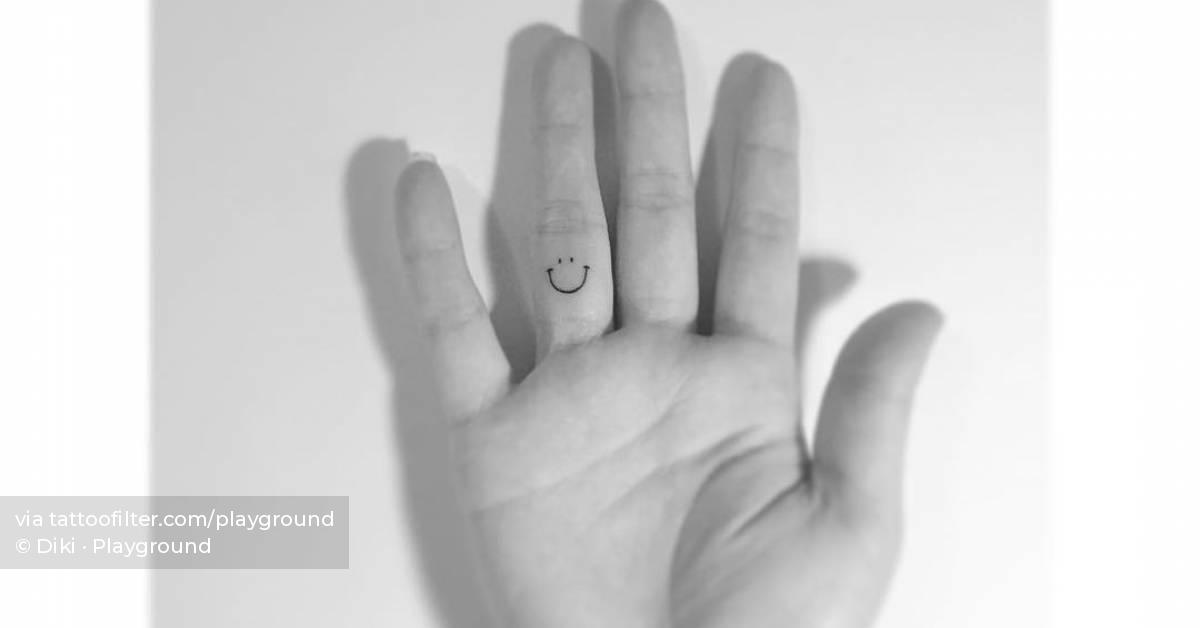 Minimalistic smiley face tattoo done on the finger.