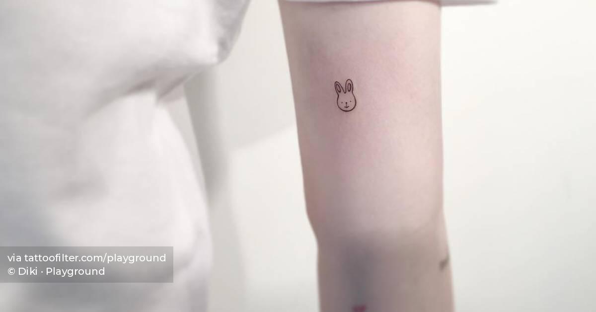 Minimalistic style bunny portrait tattoo located on the