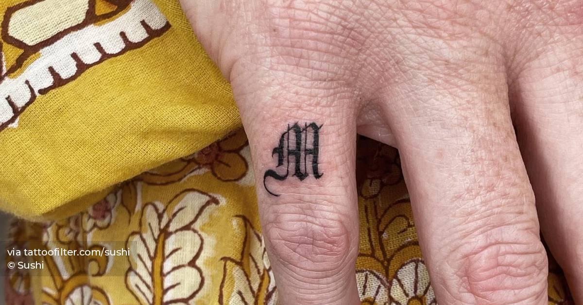 Letter "M" tattooed on the finger.