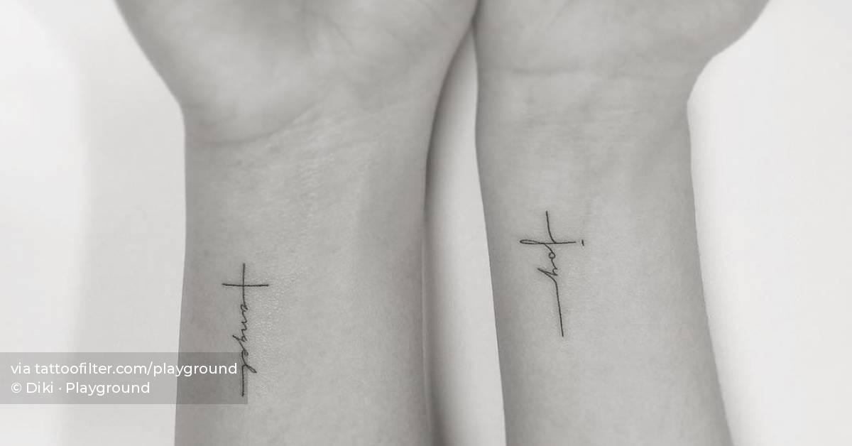 Cross lettering tattoos located on the wrist.