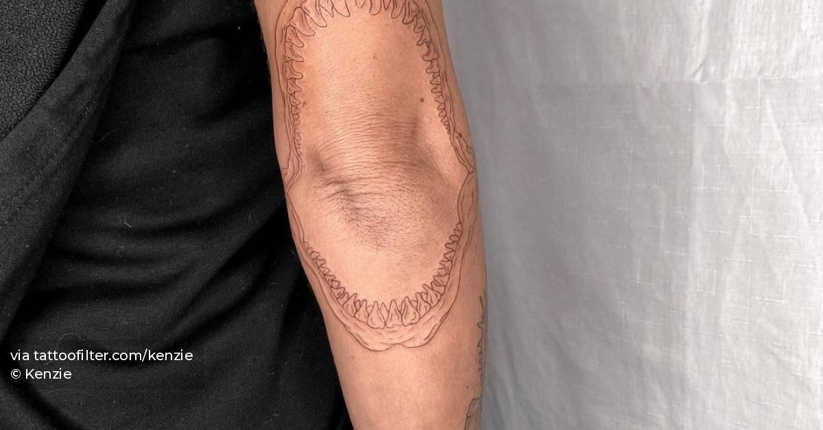 Shark teeth tattoo located on the elbow, fine line
