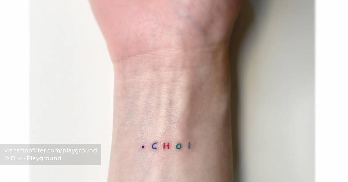 "Choi" lettering tattoo located on the wrist.
