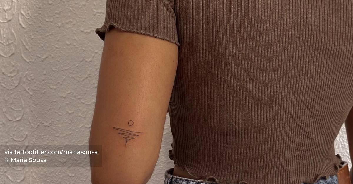 Fine line sea sunset tattoo located on the tricep.