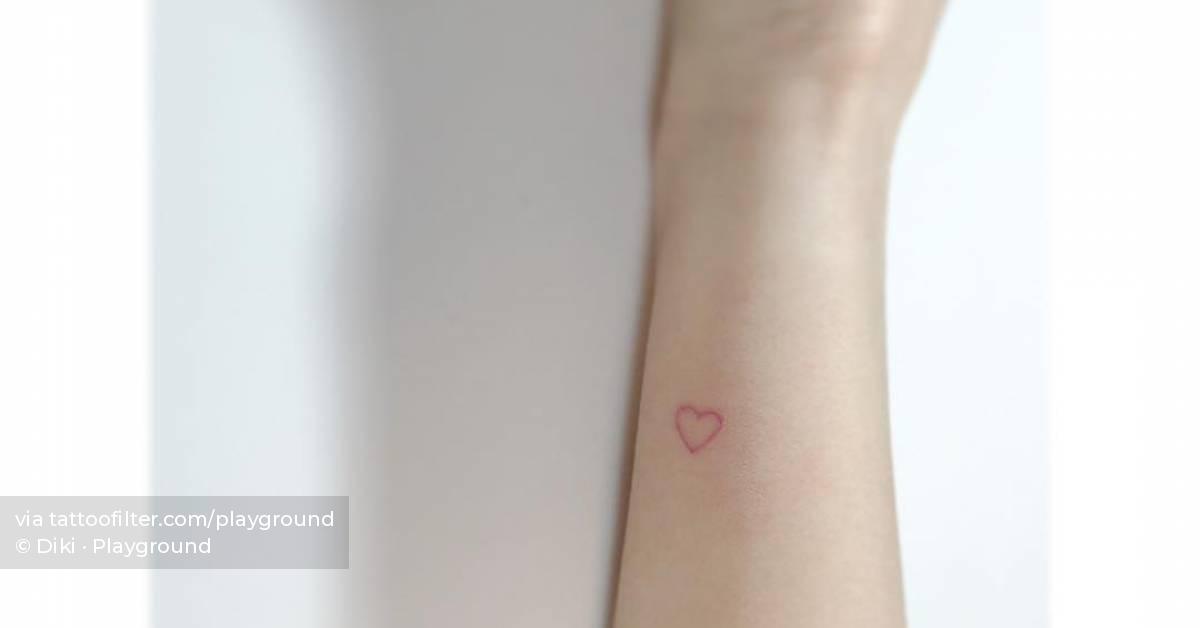 Tiny minimalistic red heart tattoo located on the