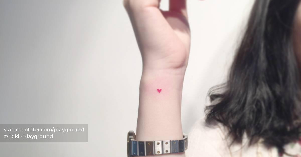 Micro red heart tattooed on the wrist, minimalistic