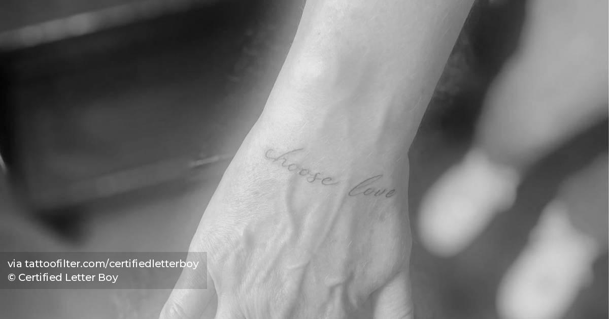 "Choose love" lettering tattoo located on the hand.