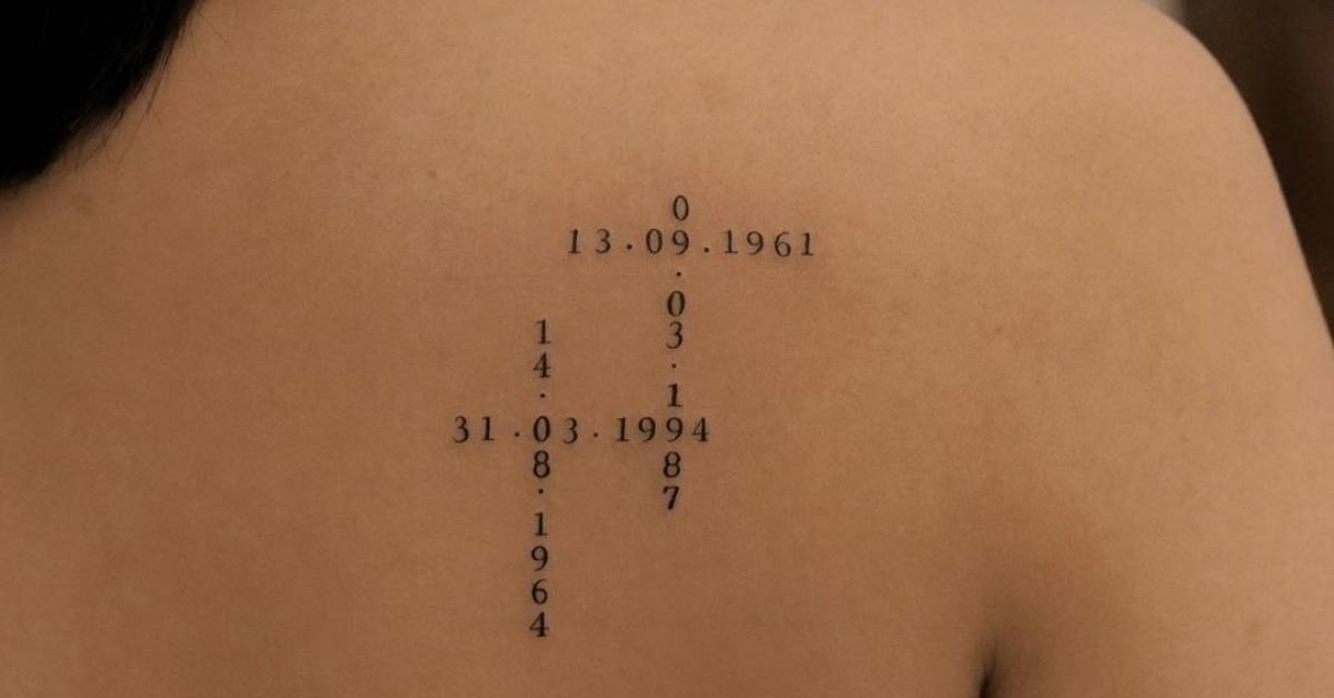 Dates in the shape of a cross tattooed on the shoulder