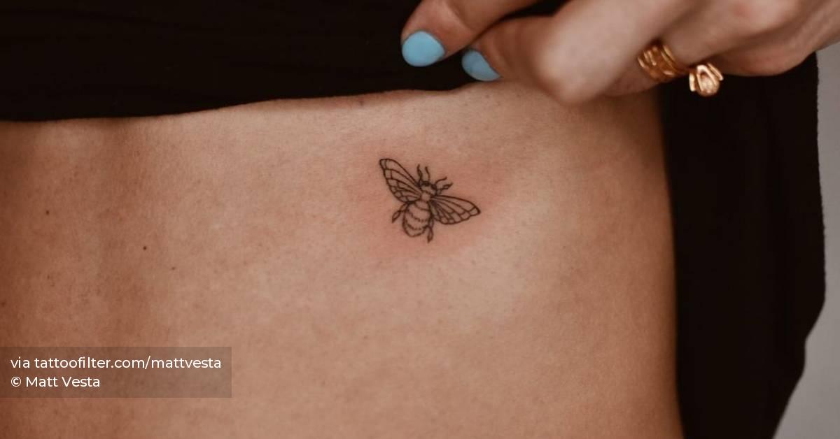 Minimalistic bee tattooed on the rib.