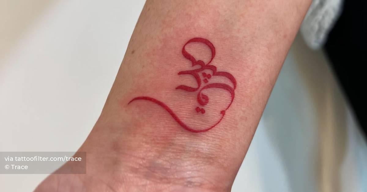 Arabic lettering tattoo in red ink located on the