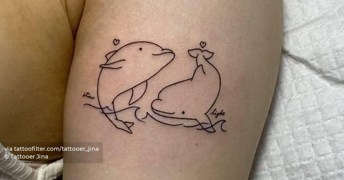 Fine line dolphin tattoo on the upper arm