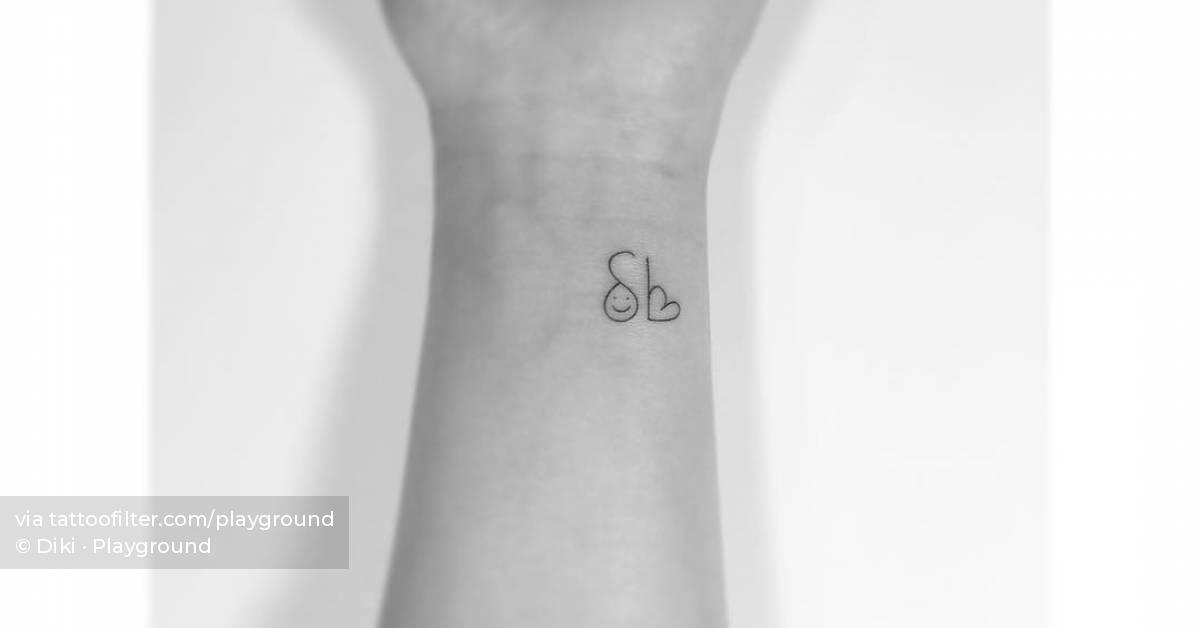 Initials "SH" with a smiley face and hear tattooed on