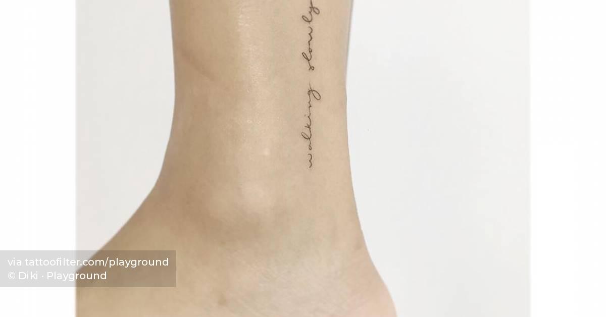 "Walking slowly" lettering tattoo located on the ankle.