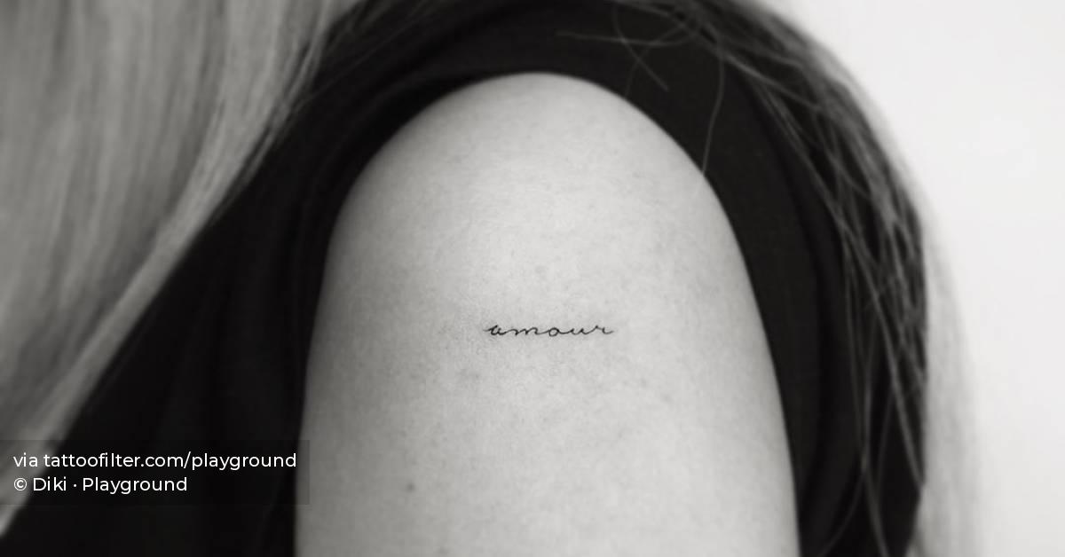"Amour" lettering tattoo located on the upper arm.