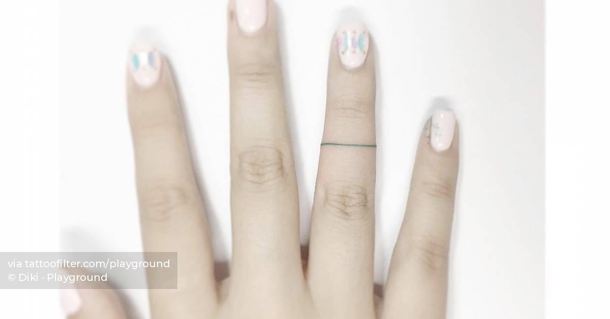 Line art ring tattoo located on the finger.