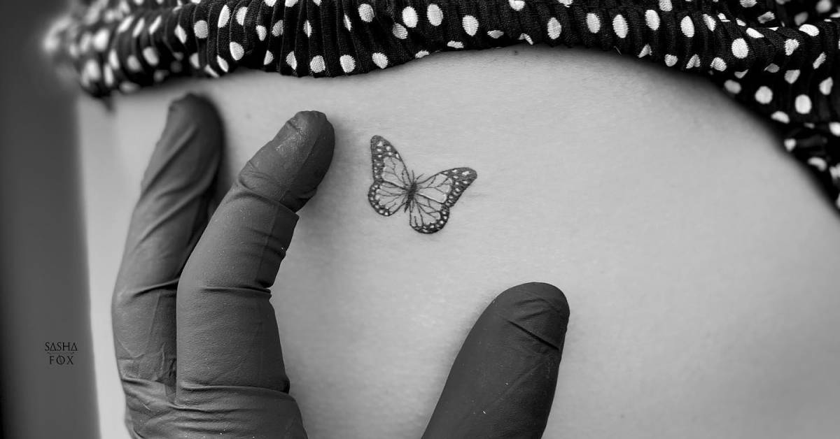 Fine line butterfly tattooo located on the rib.