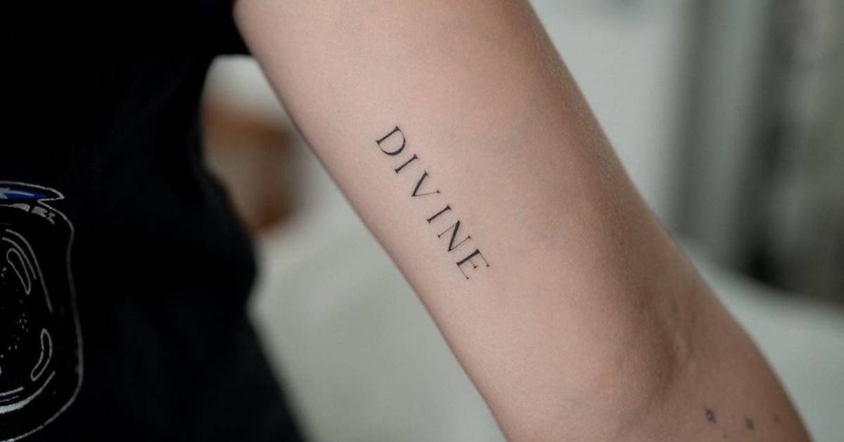 Tattoo Of The Word divine Located On Lili Reinhart s Tattoo Of The Word divine Located On Lili Reinhart s