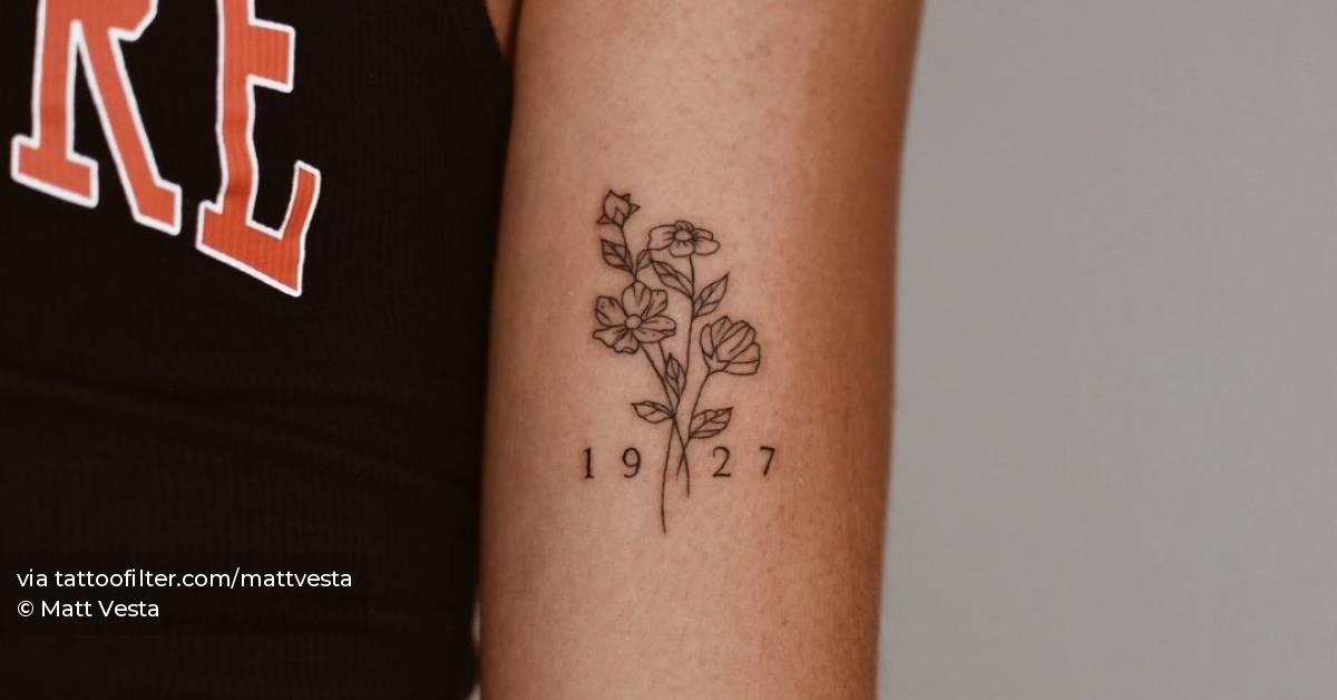 Flower bouquet and "1927" tattooed on the bicep.