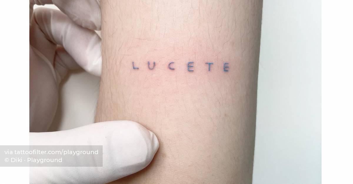 Tattoo of the word "lucete" done in blue ink.