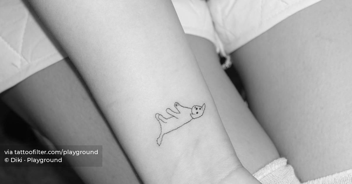 Fine line minimalistic dog tattoo located on the wrist.