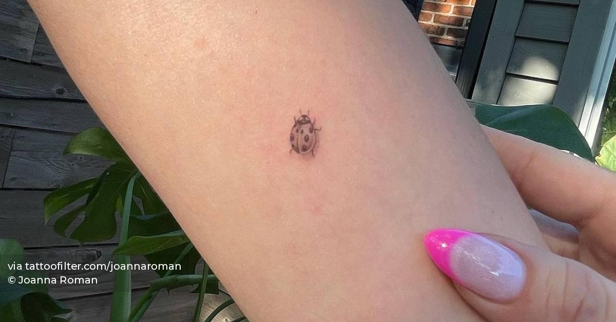 Micro-realistic ladybug tattoo located on the inner