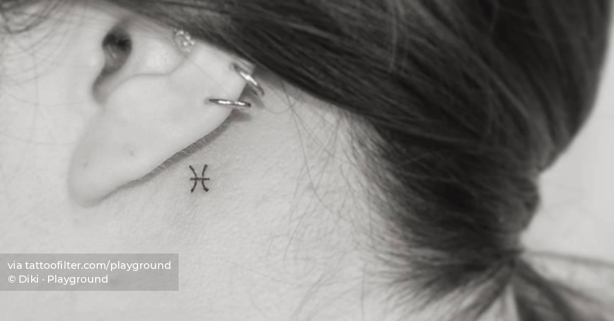 Tiny Pisces zodiac symbol tattooed behind the ear.