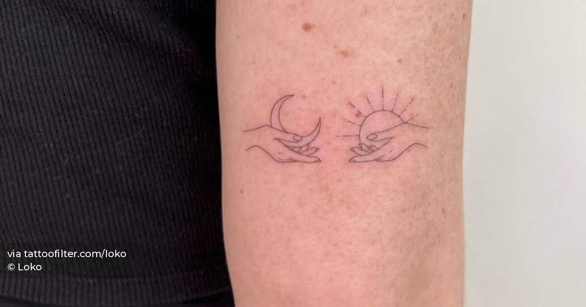 Hands holding sun and moon tattoo located on the