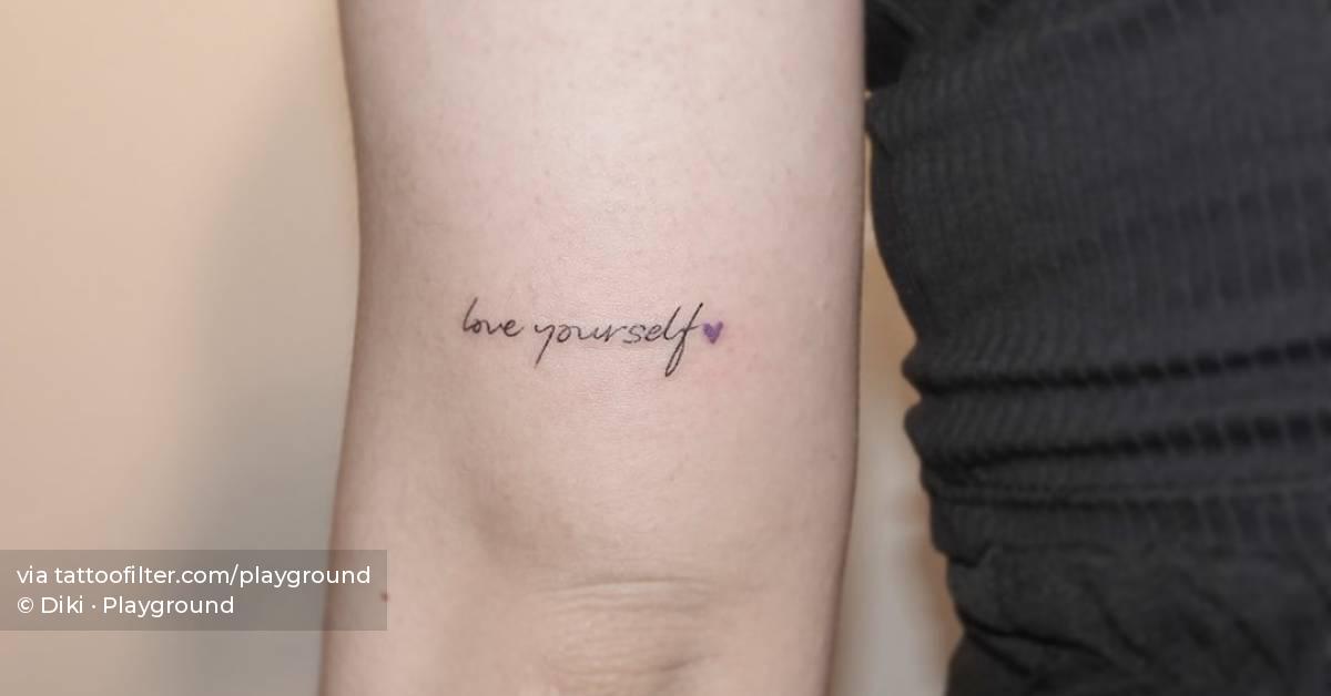 Tattoo that says "love yourself" handwritten on the