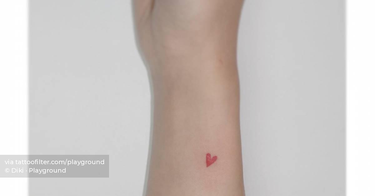 Tiny minimalistic red heart tattoo done on the wrist.