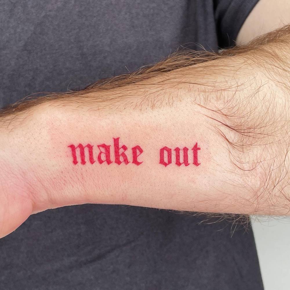 Tattoo That Says make Out In Red Ink Located On The