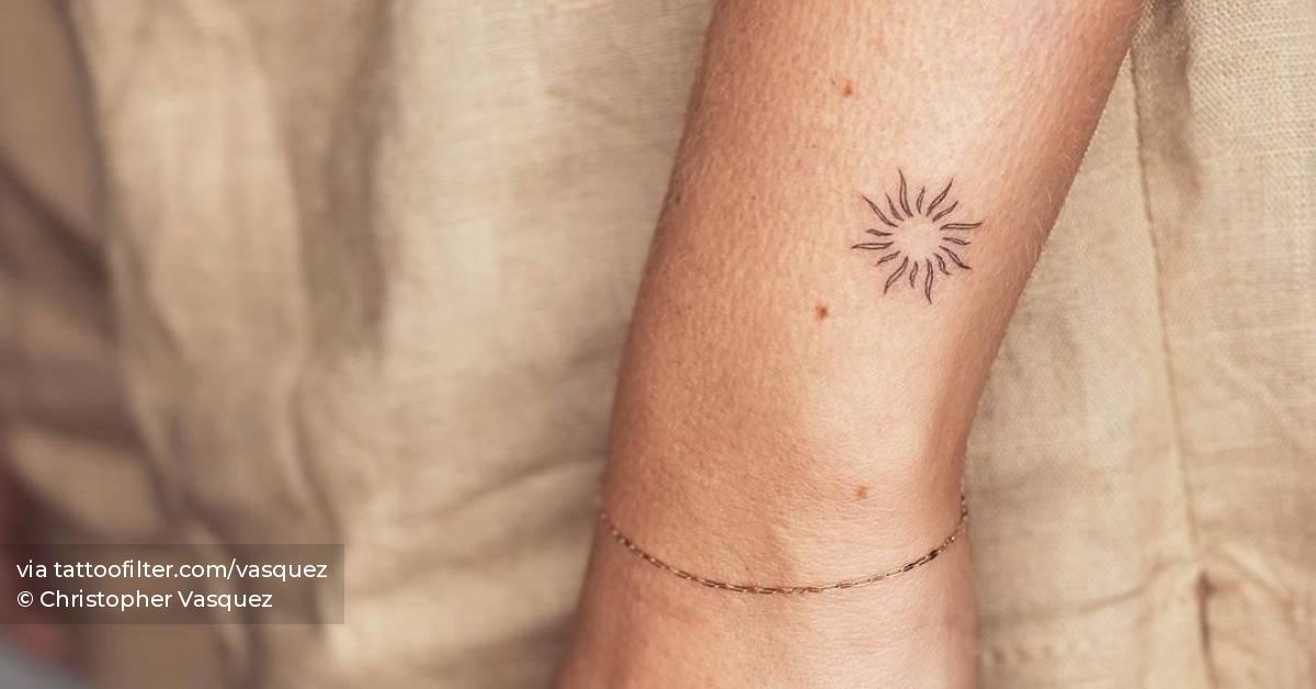 Fine line sun tattoo done on the wrist.