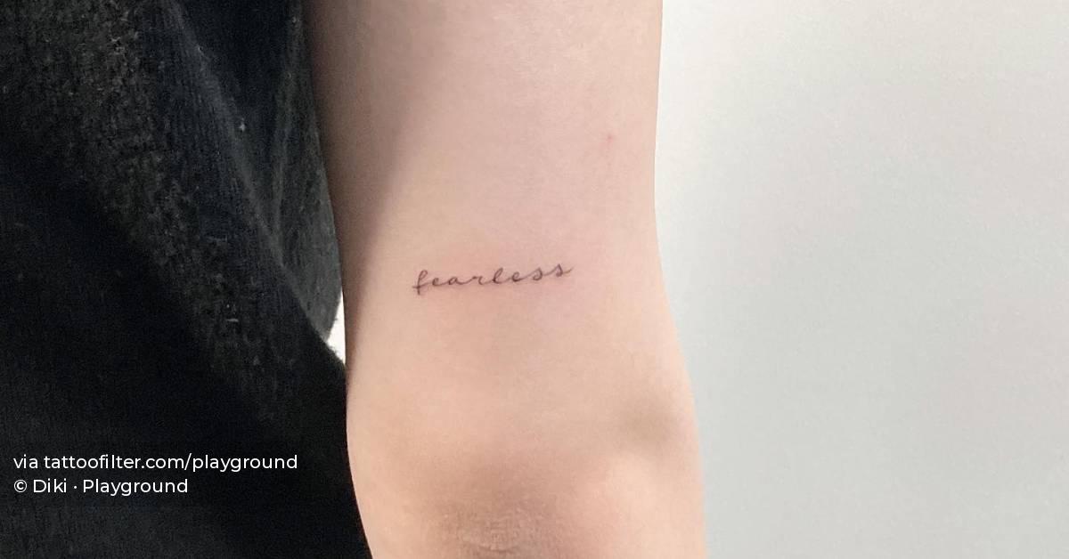 Tattoo of the word "fearless" handwritten on the
