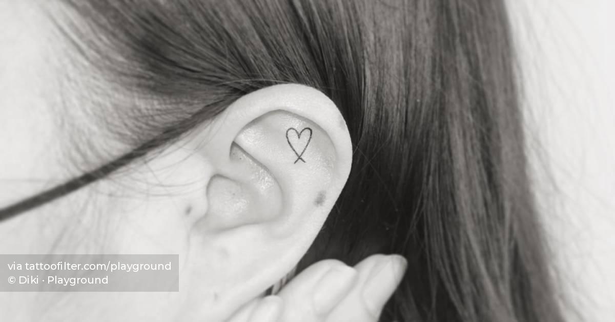 Minimalistic style heart tattoo located on the ear,