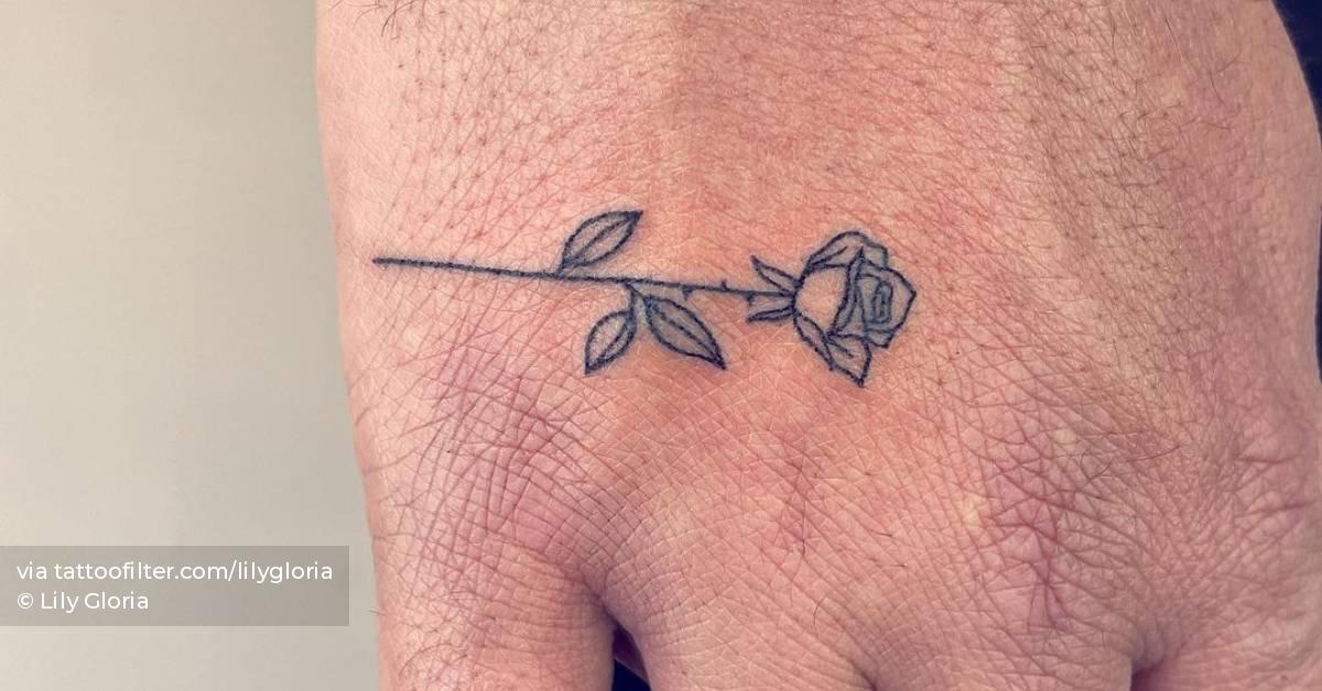 Hand poked fine line rose tattoo located on the hand.