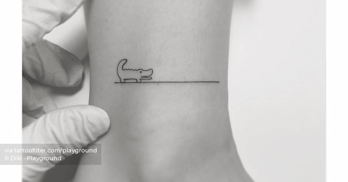 Fine line crocodile tattoo located on the ankle.
