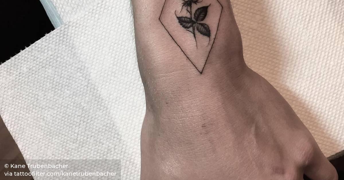 Blackwork style rose tattoo inside a rhombus.