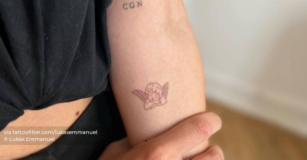 Fine line style cherub tattoo located on the inner