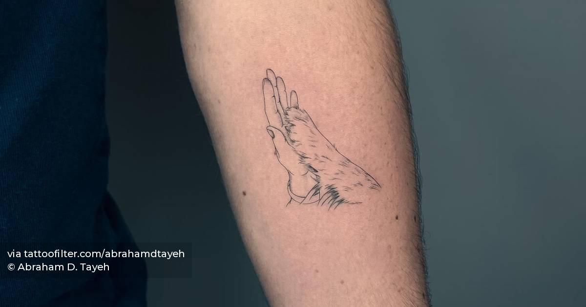 Hand and paw tattoo located on the inner forearm.